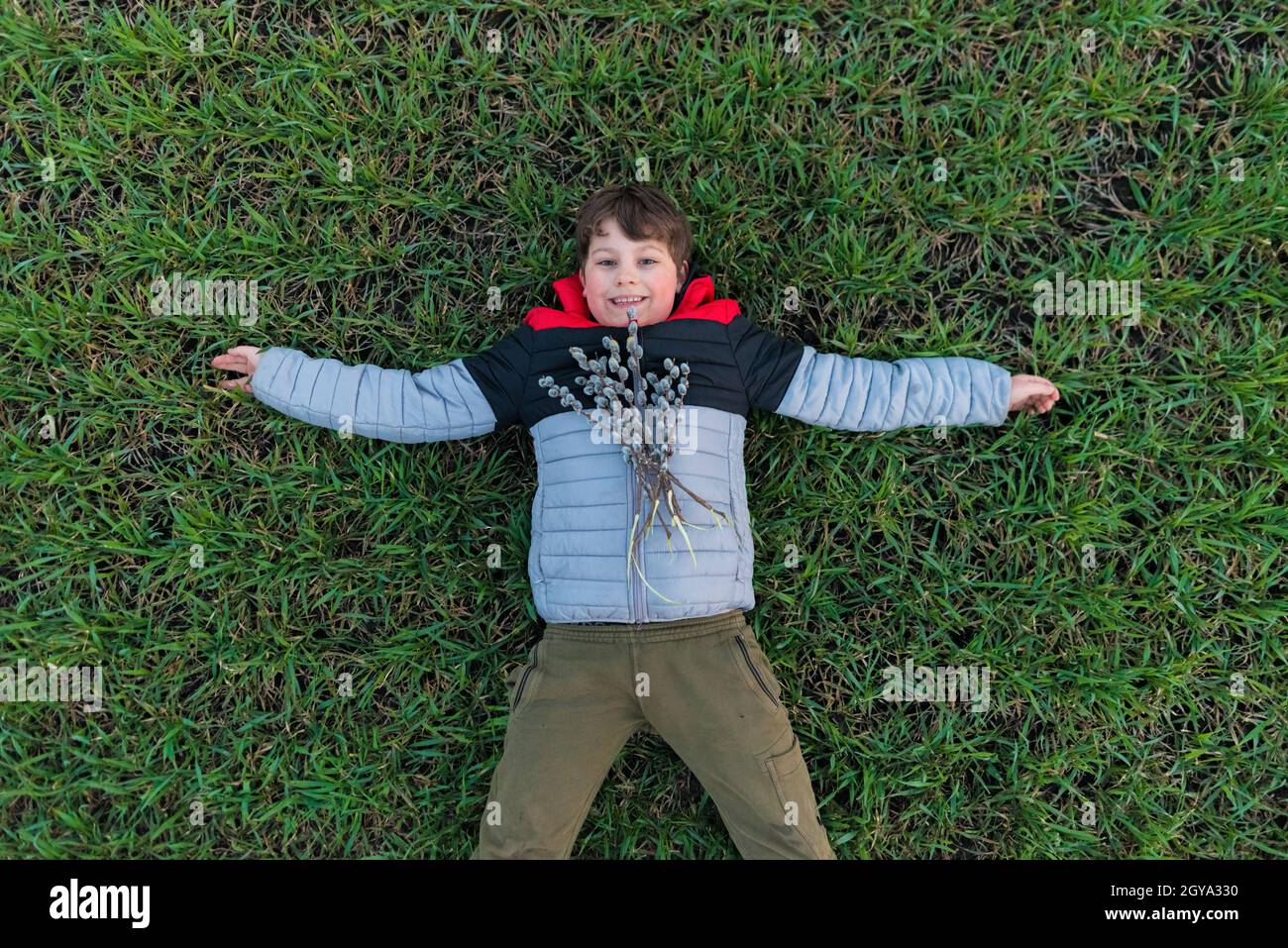 smiling teen boy lies on green grass with his arms Stock Photo - Alamy