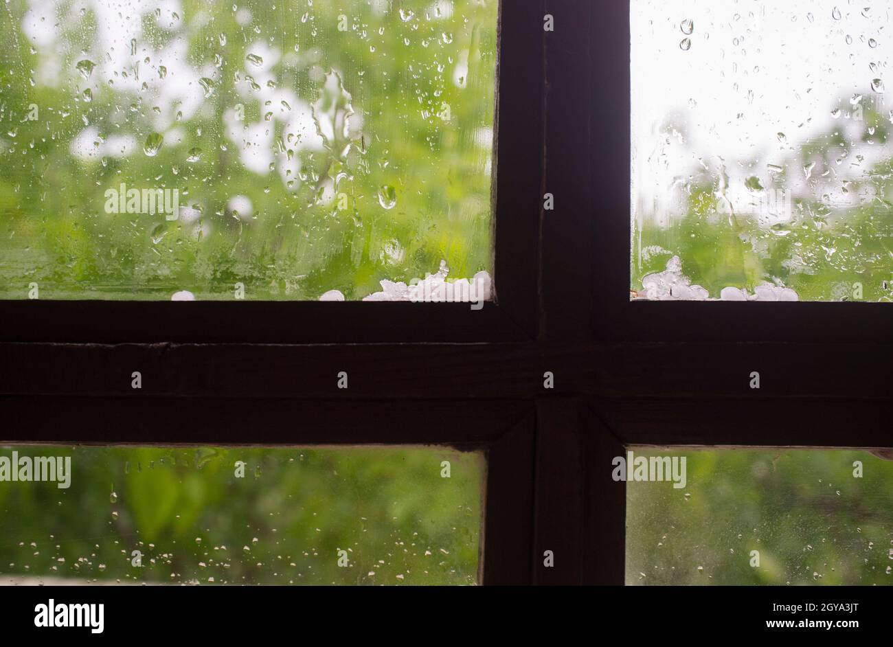 Hail over wooden window frame. Selective focus over green background ...