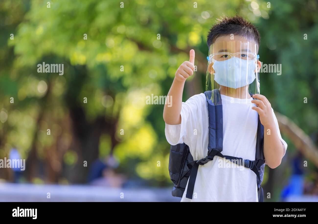 Happy kid wearing mask and face shield . showing thumbs up Stock Photo ...