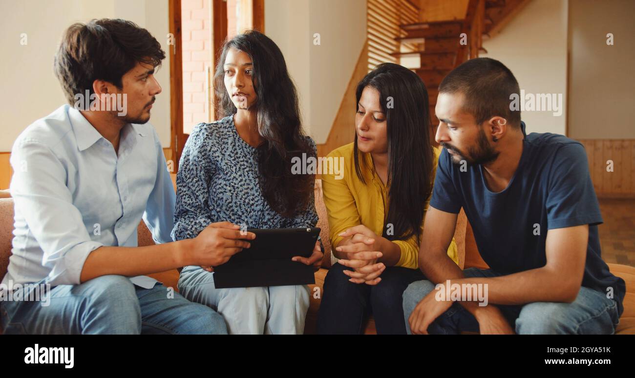 Close up shot of a four South Asian persons sitting and having ...