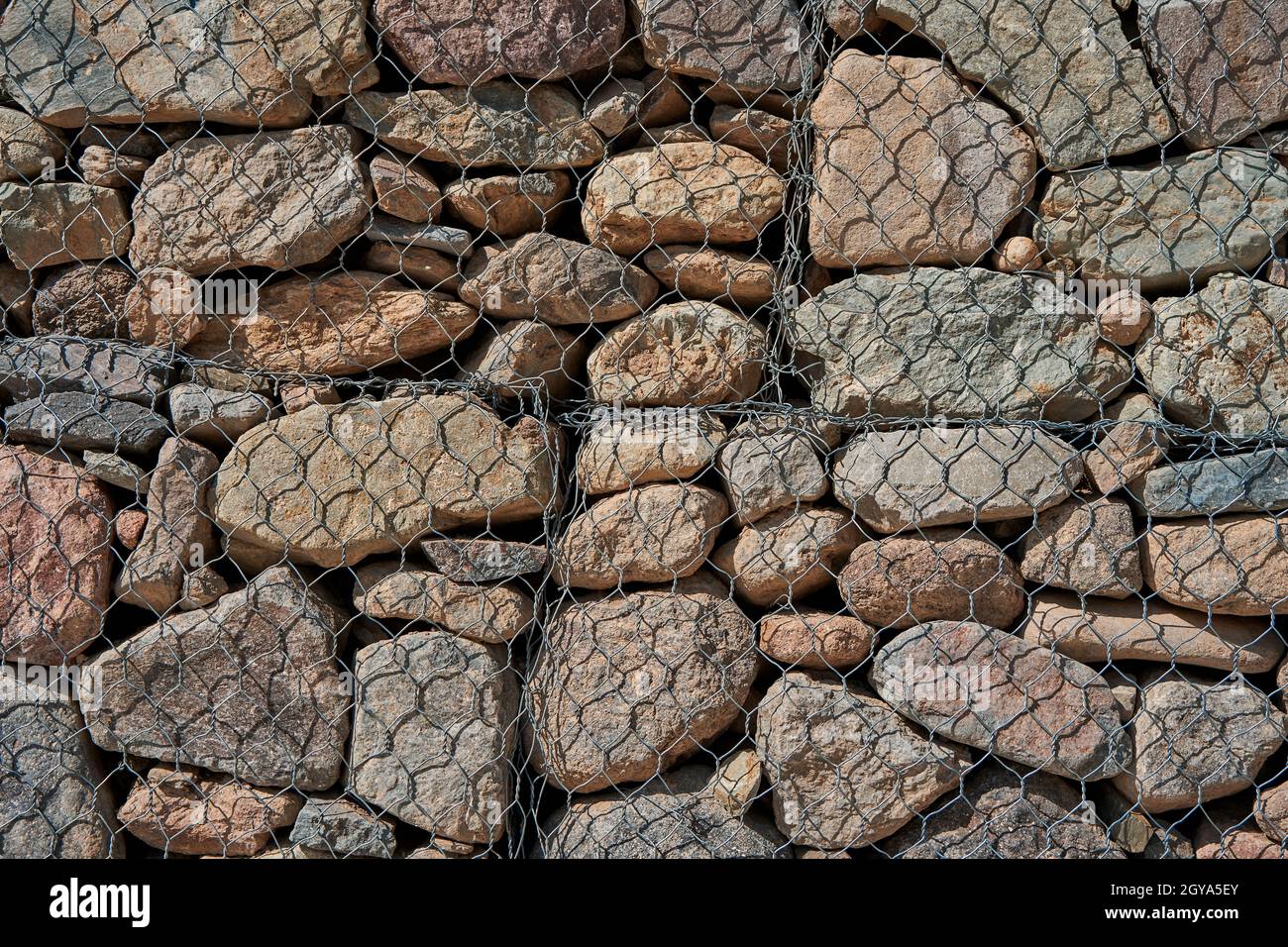 The cliff along the road is covered with metal mesh to protect it from ...