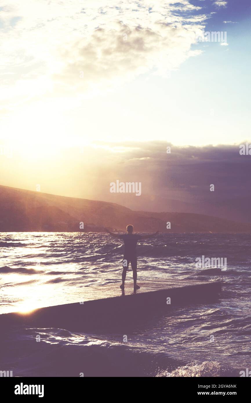 Feeling of freedom concept. Man standing on pier facing to the sea with ...