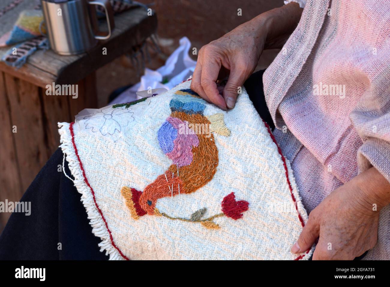 A woman stitches a traditional hispanic colcha embroidery textile at El ...