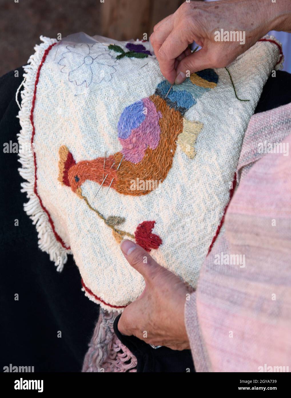A woman stitches a traditional hispanic colcha embroidery textile at El ...