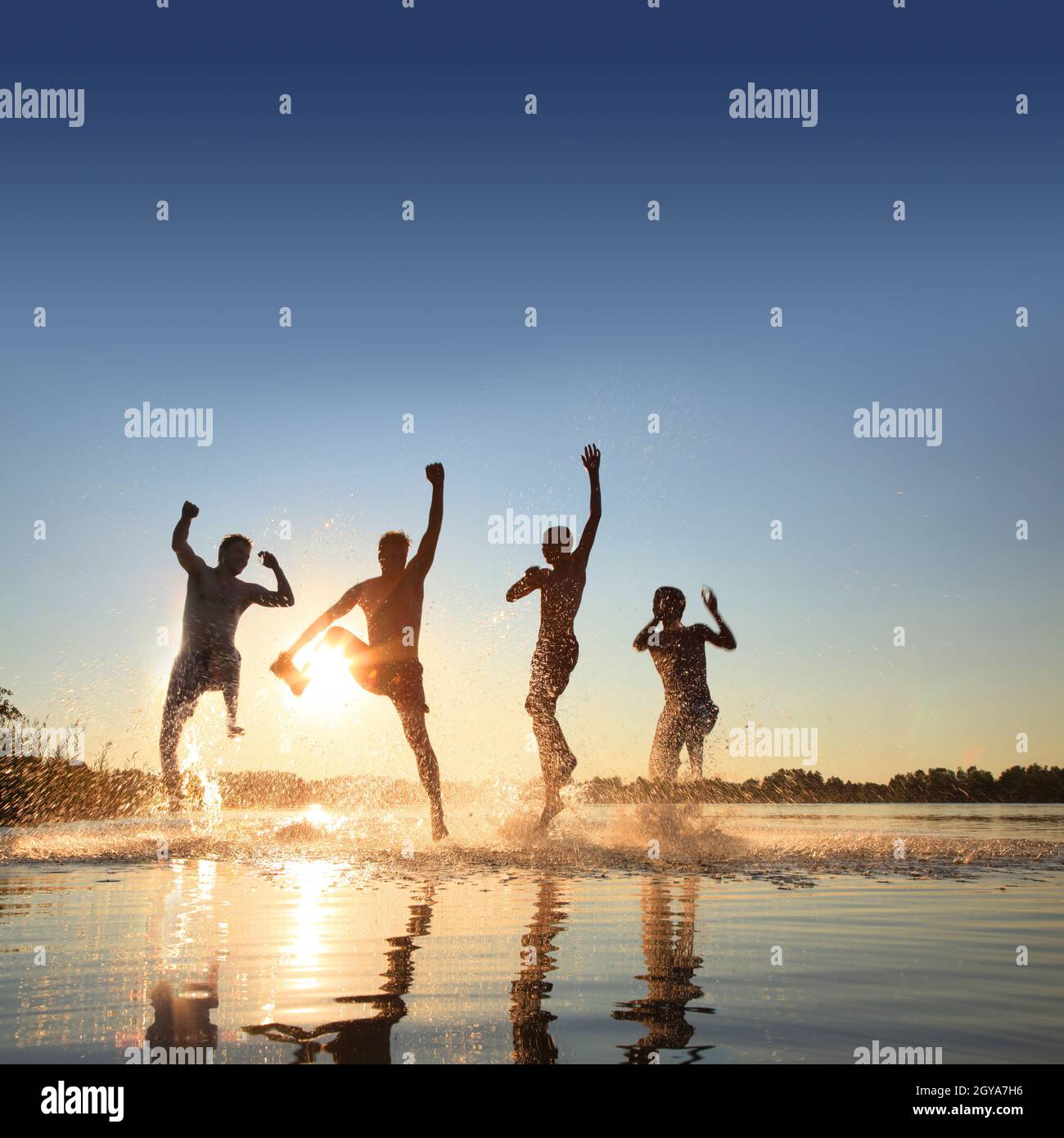 Group of young people playing games on sandy beach on a summer day ...