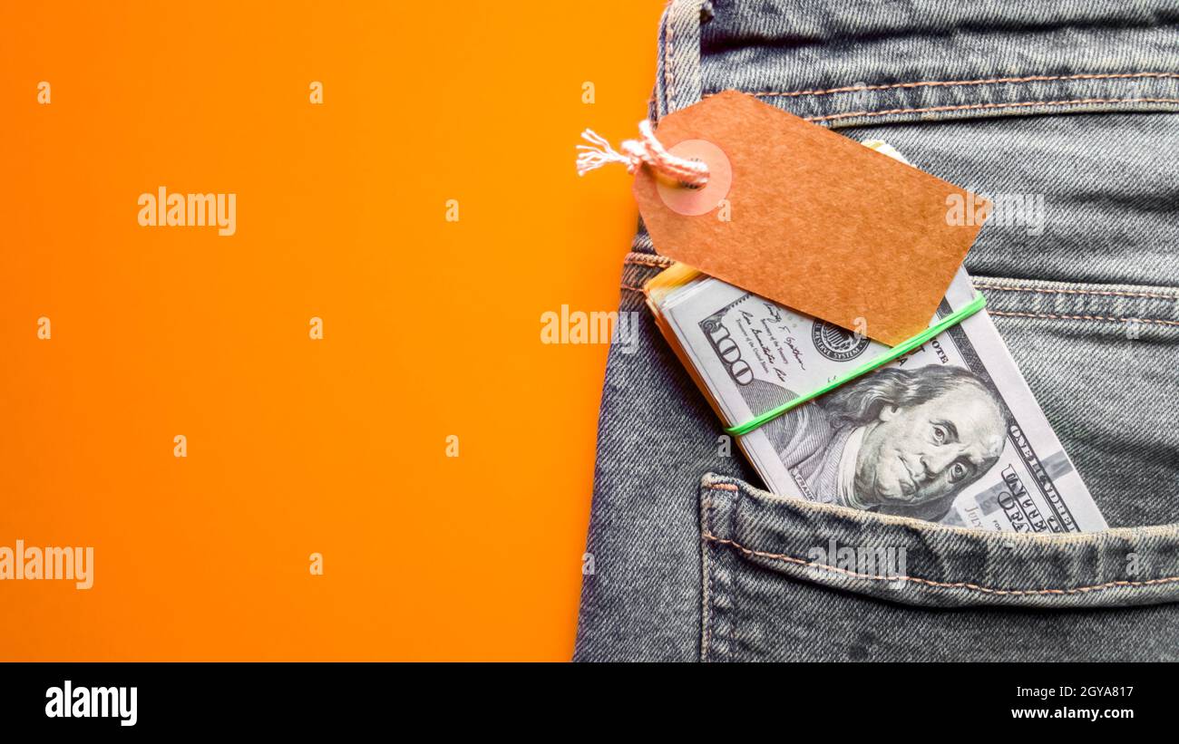 Many hundreds of dollars banknotes in a jeans pocket in a purse with a ...
