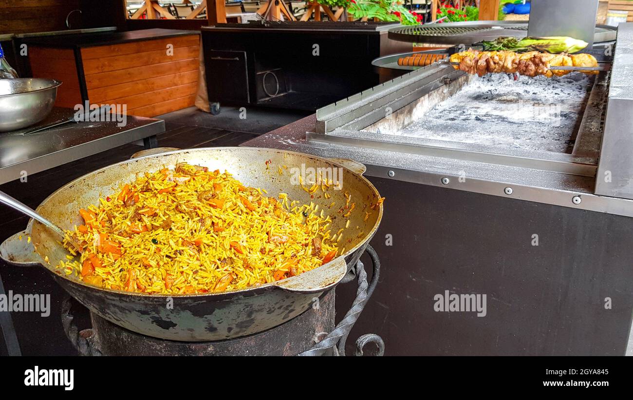 Tasty Uzbek pilaf in a cauldron in the open air at street food festival ...