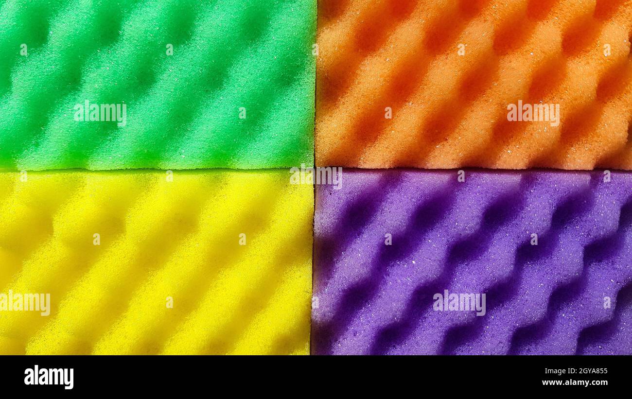 Multi-colored washcloths are laid out in rows on a bright background ...