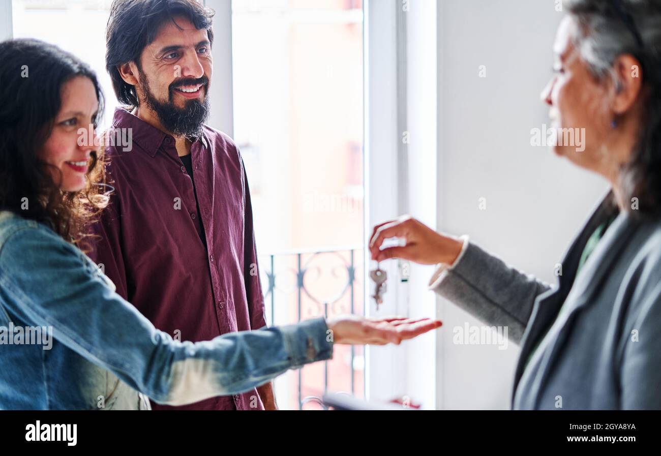 Real estate agent handing over keys to the apartment to clients Stock ...
