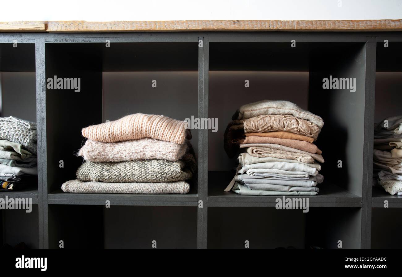 Open wardrobe with lots of folded clothes, organized closet with piled ...