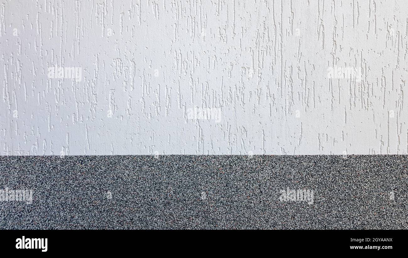 Gray marble chips and decorative light stucco on the wall divided by a ...