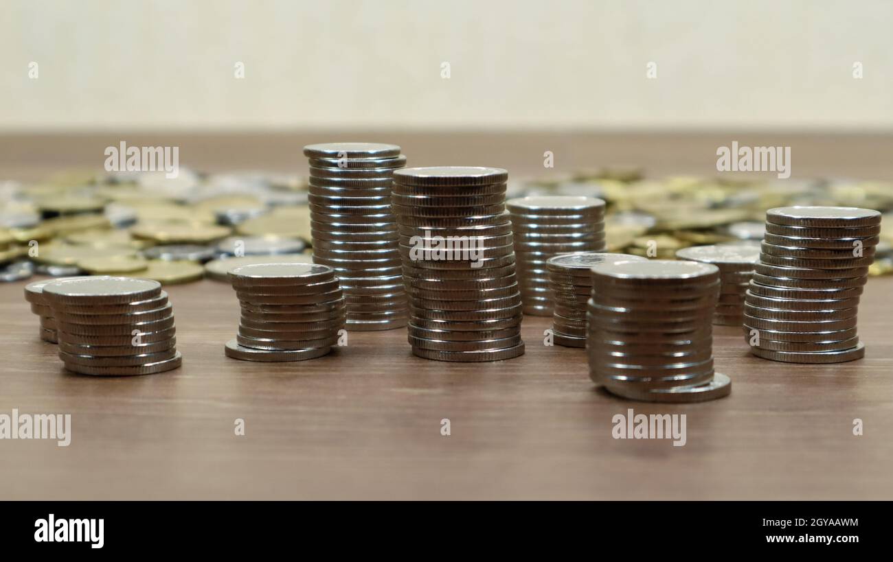 Coins are stacked on a wooden work table. Stock photo of many cents ...