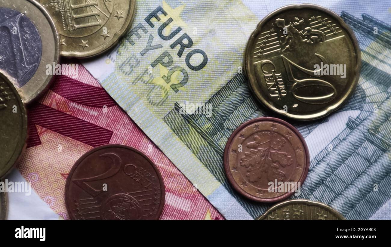 Euro banknotes and coins as background. Shot looking at the Euro ...