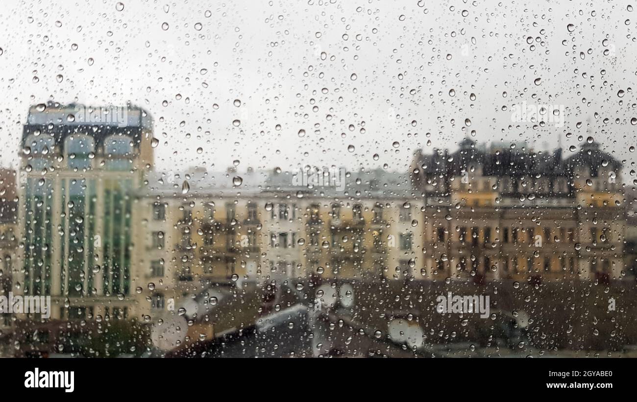Wet window with drops on the background of the autumn city in cloudy ...
