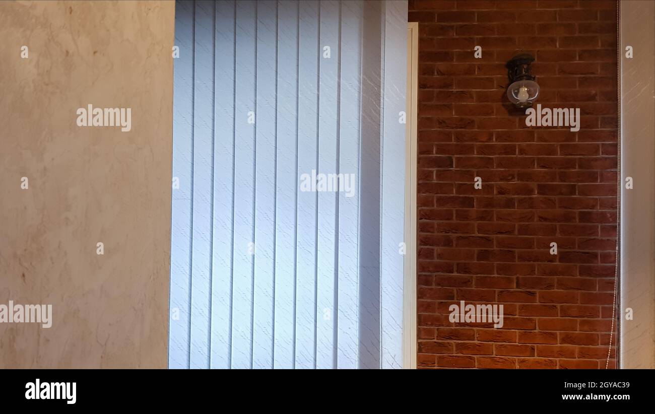 Large window with vertical white or gray blinds, loft, brick wall ...
