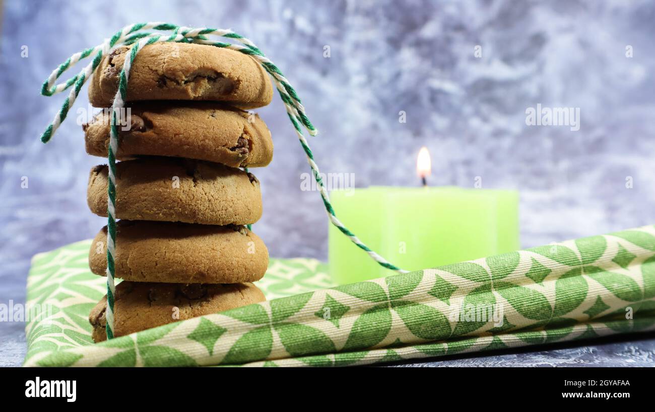 American chocolate chip cookies in a stack tied with thread on a green ...