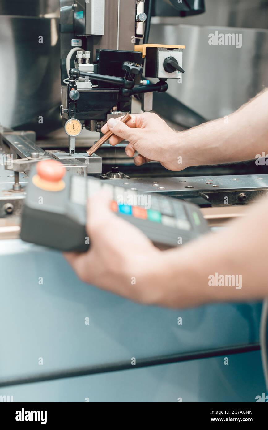 Close-up of Worker in factory putting tool into a punching machine ...