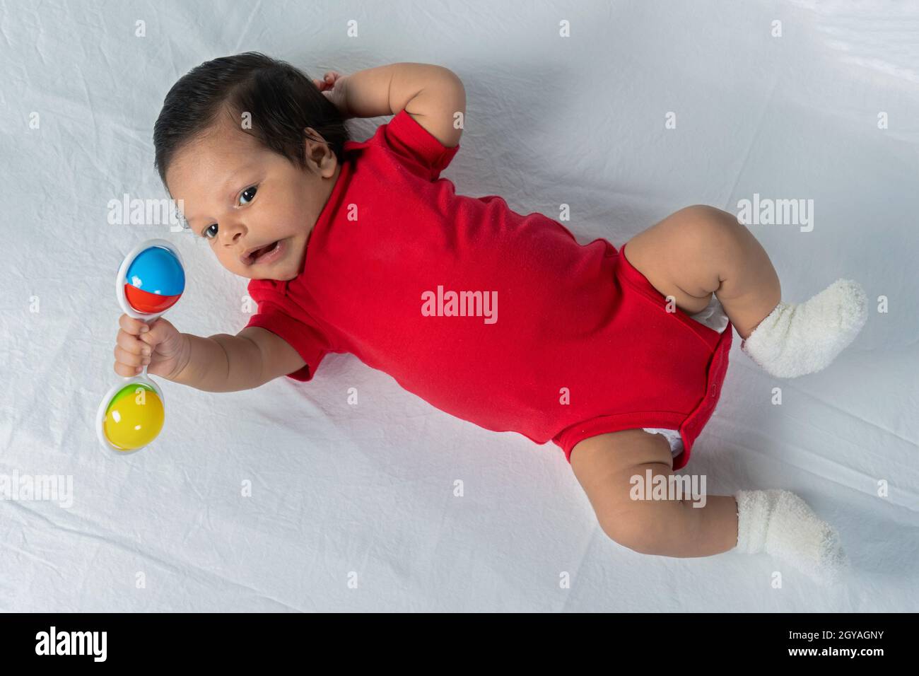 Baby lying on back holding toy hi-res stock photography and images - Alamy