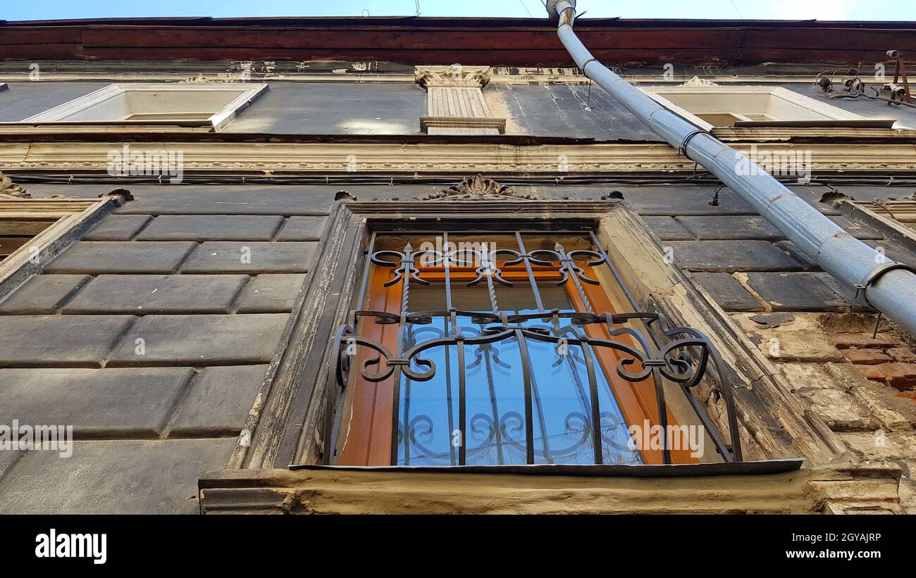 Window, pilaster and downpipe of an old black building in the historic ...