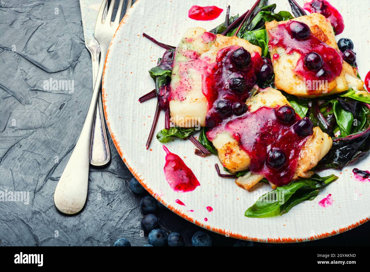 Delicious baked fish with berry sauce. Stewed pangasius with ...