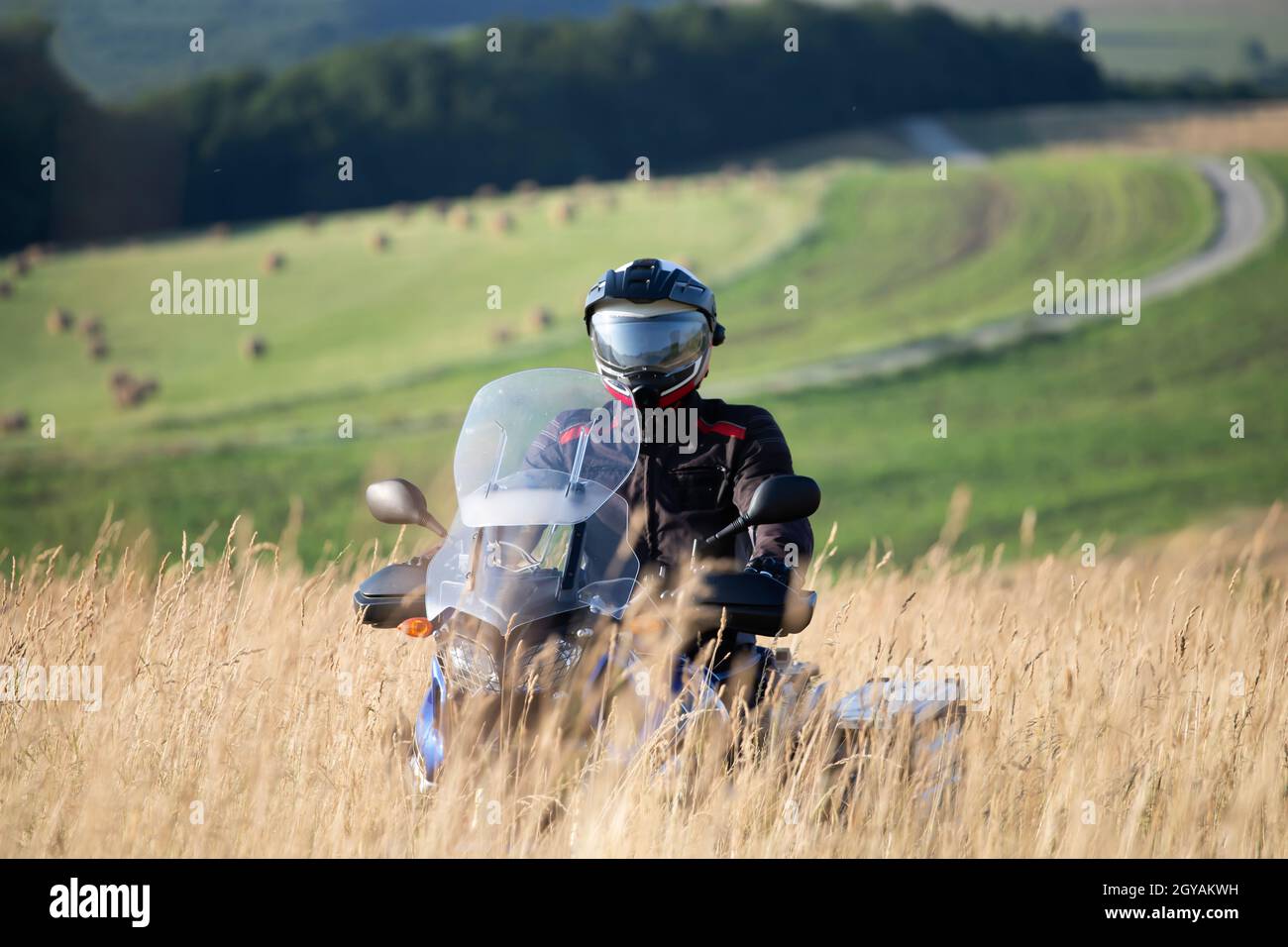 Motorcycle driver riding on countryside hills. Travel and sport, speed ...