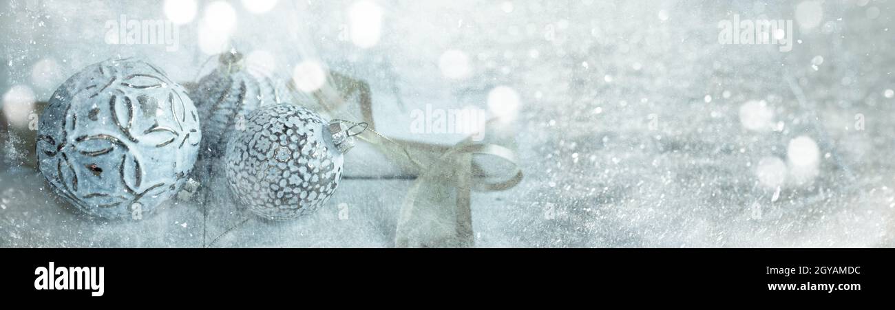 White christmas ornaments in snow with shining bokeh. Winter and christmas background with ...