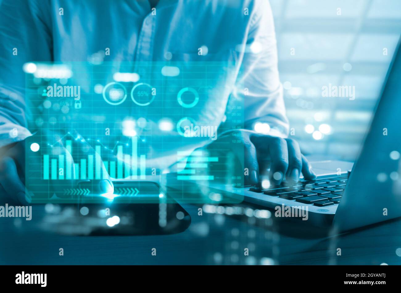business chart and graph. Businessman using computer laptop and smart phone virtual hologram ...