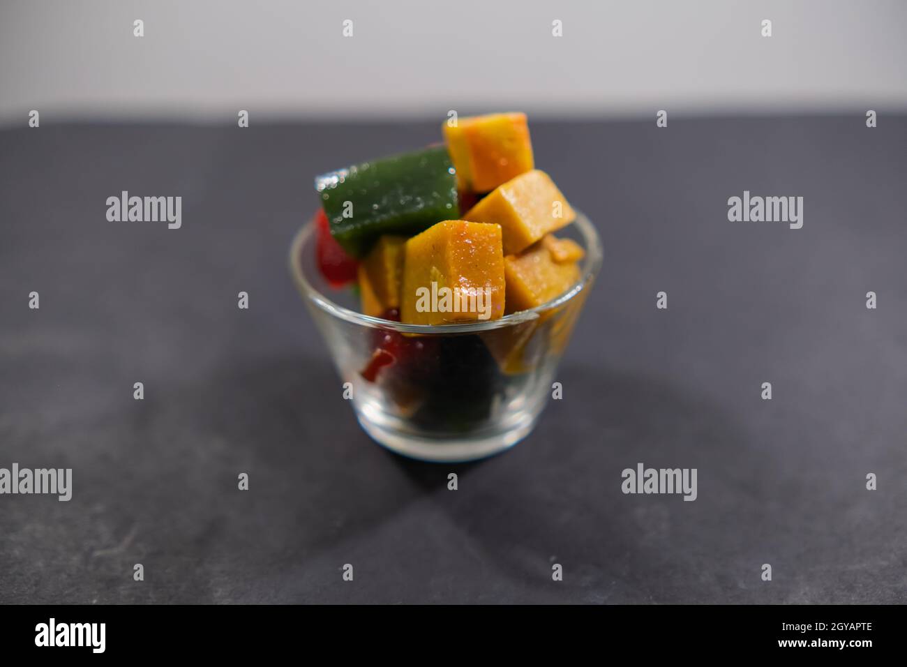 Glass of colorful Mexican fruit paste slices on black surface Stock ...