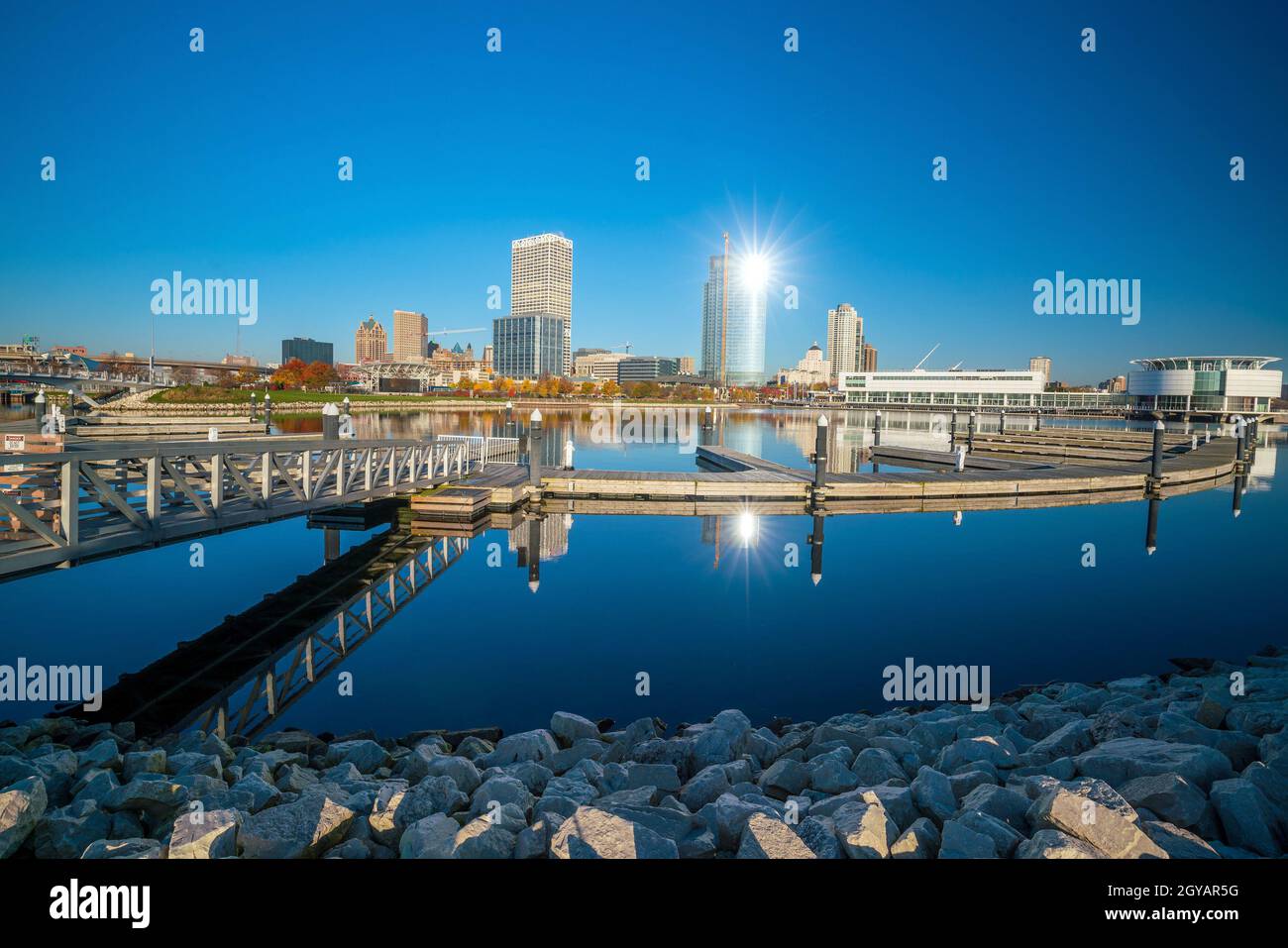 Milwaukee skyline with city reflection in lake Michigan and harbor pier ...