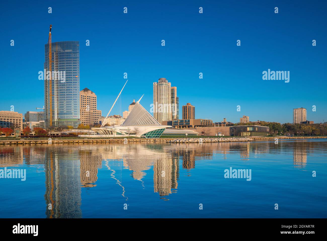 Milwaukee skyline with city reflection in lake Michigan and harbor pier ...