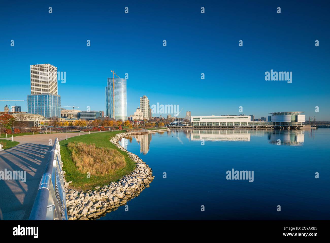 Milwaukee skyline with city reflection in lake Michigan and harbor pier ...