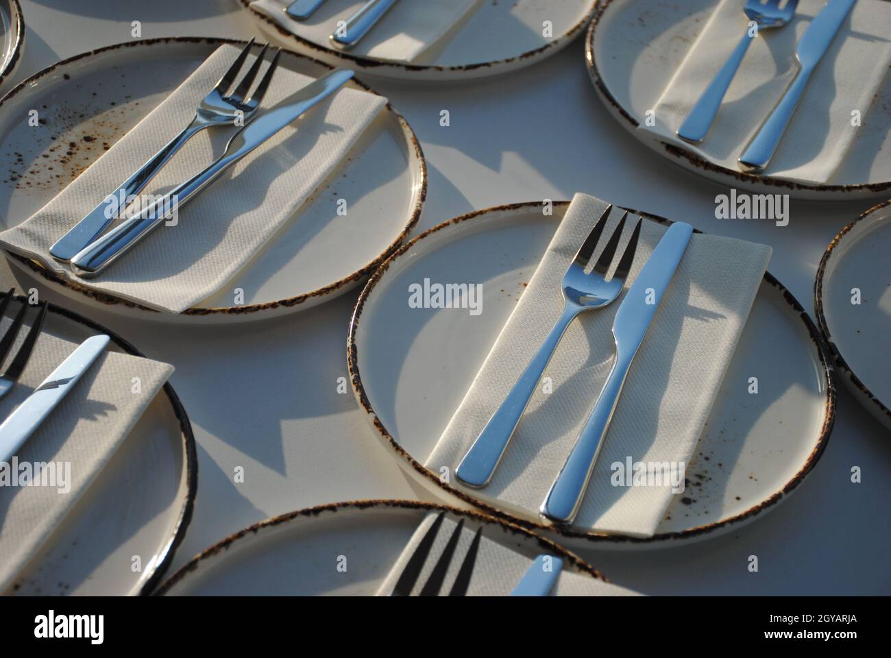Stylish elegant table setting on sunset light background Stock Photo ...