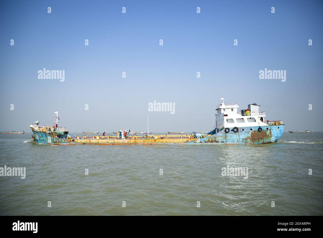 Old rusty ship in the beautiful blue sea Stock Photo - Alamy