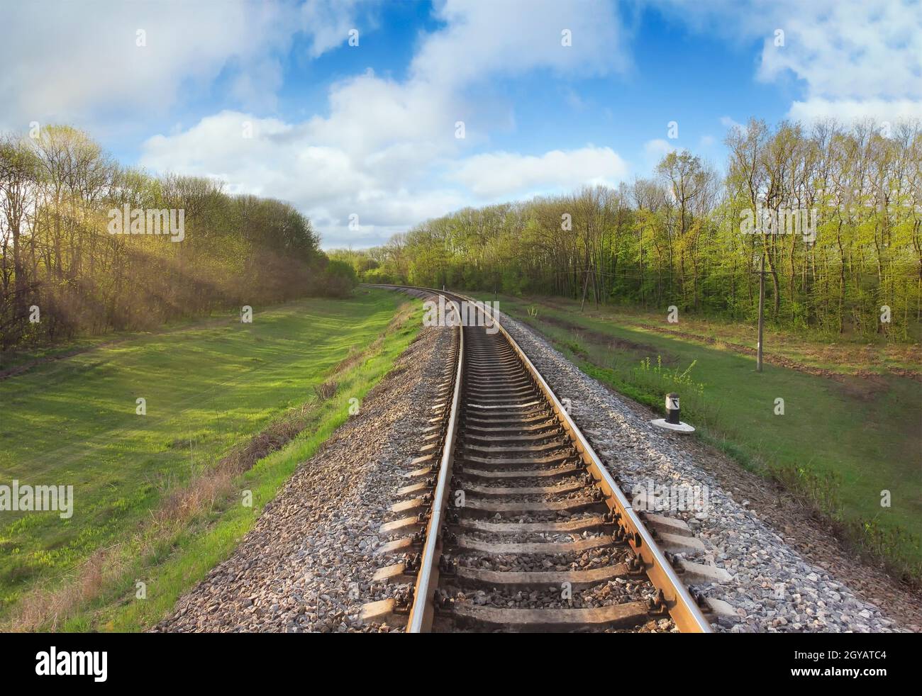 Railroad tracks with the morning sun shining through the branches of ...