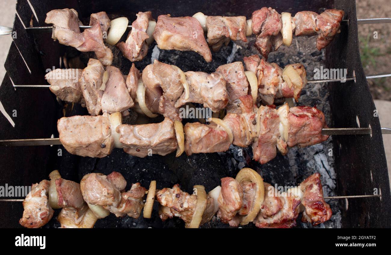 Meat slices with onion rings that are put on a skewer, the kebab slowly ...