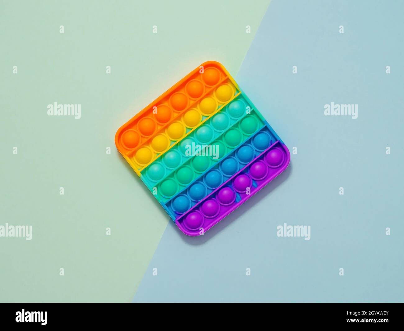 Popit or simple dimple toy, top view over two-shadows blue background ...