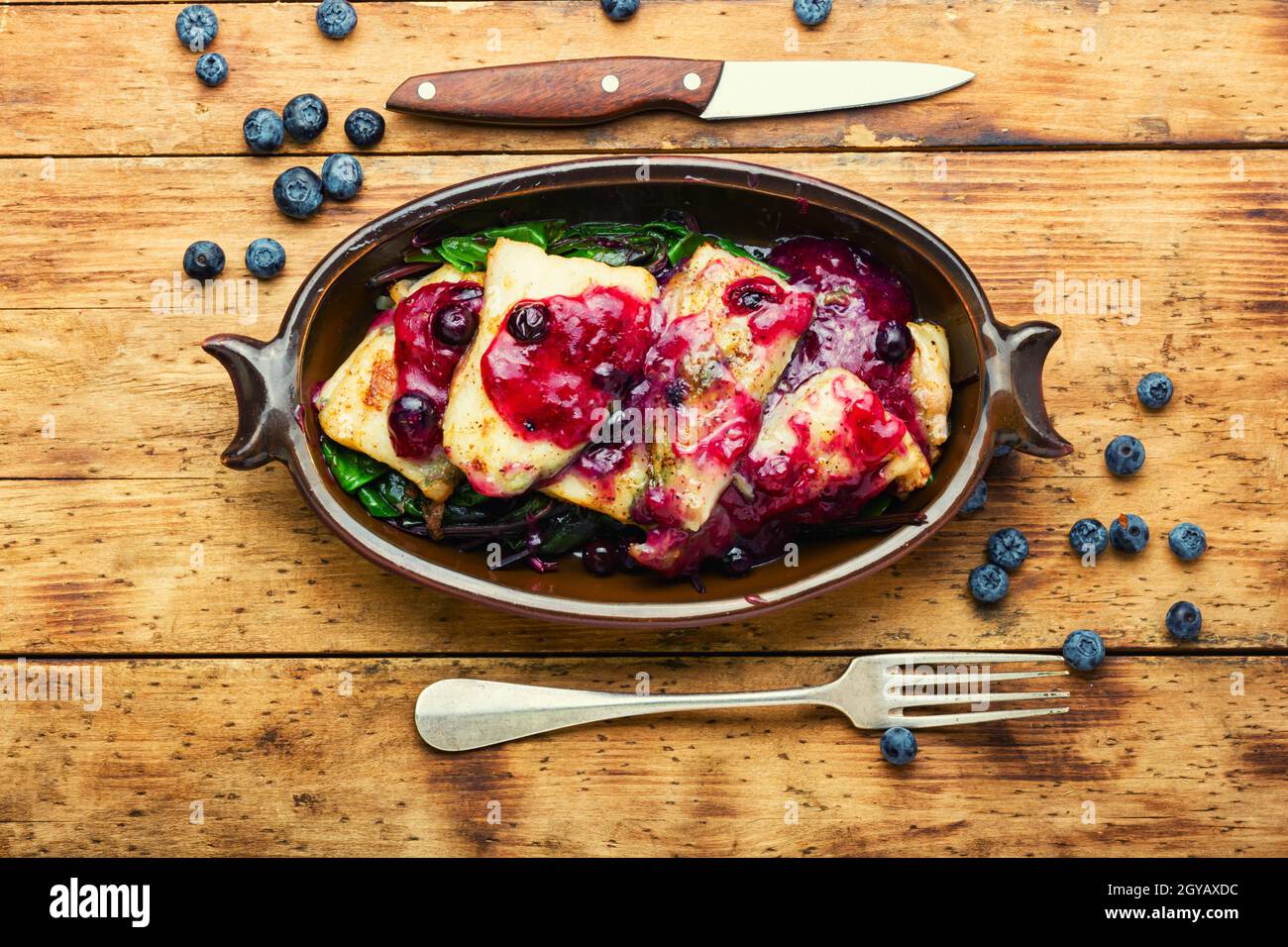 Delicious baked fish with berry sauce. Stewed pangasius with ...