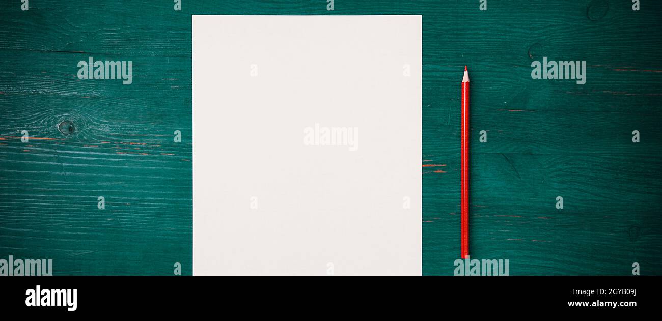 A blank white sheet and pencil for drawing on a wooden background with ...