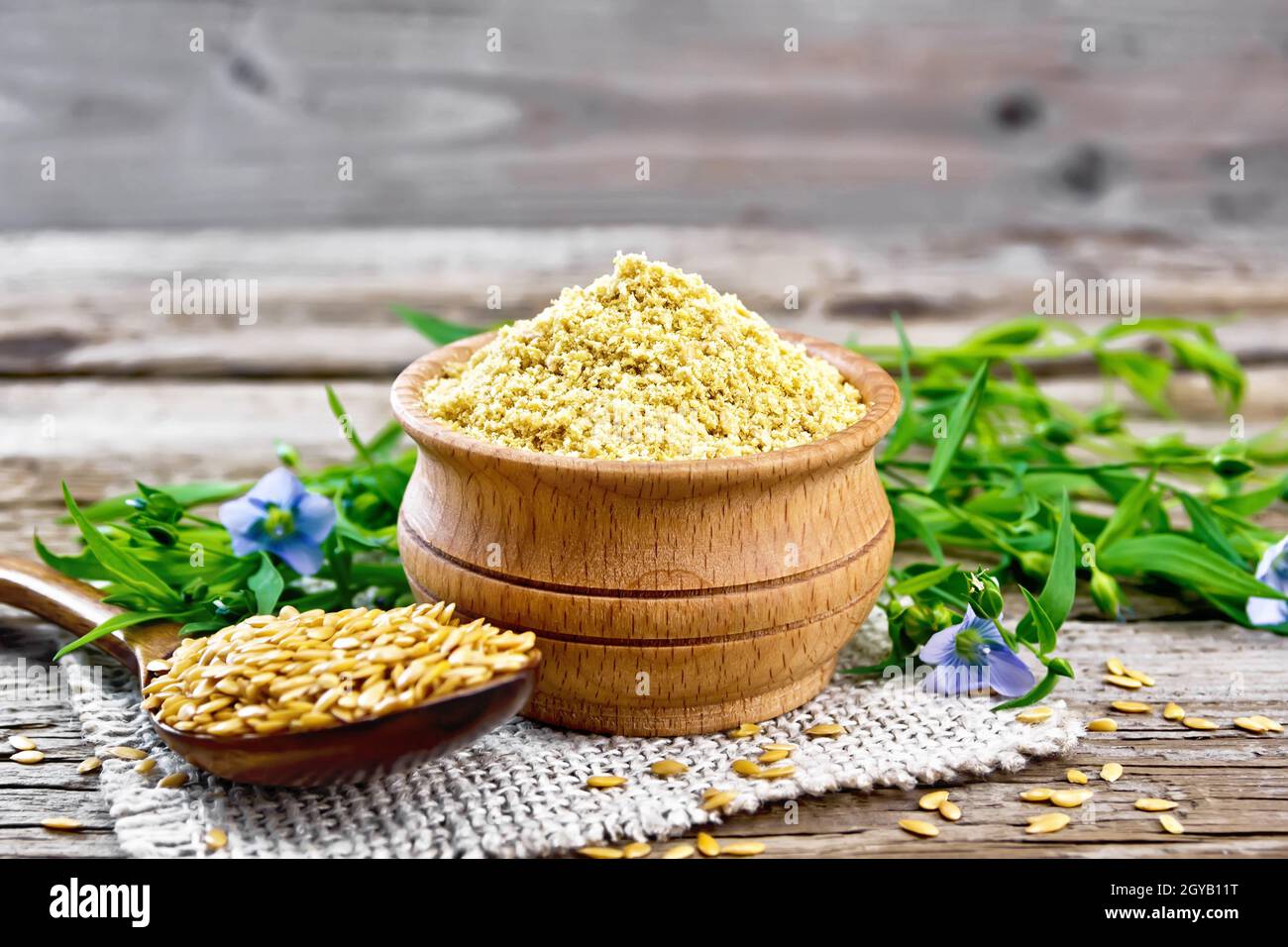 Linen bran in a bowl, seeds in spoon on sacking, flax leaves and ...