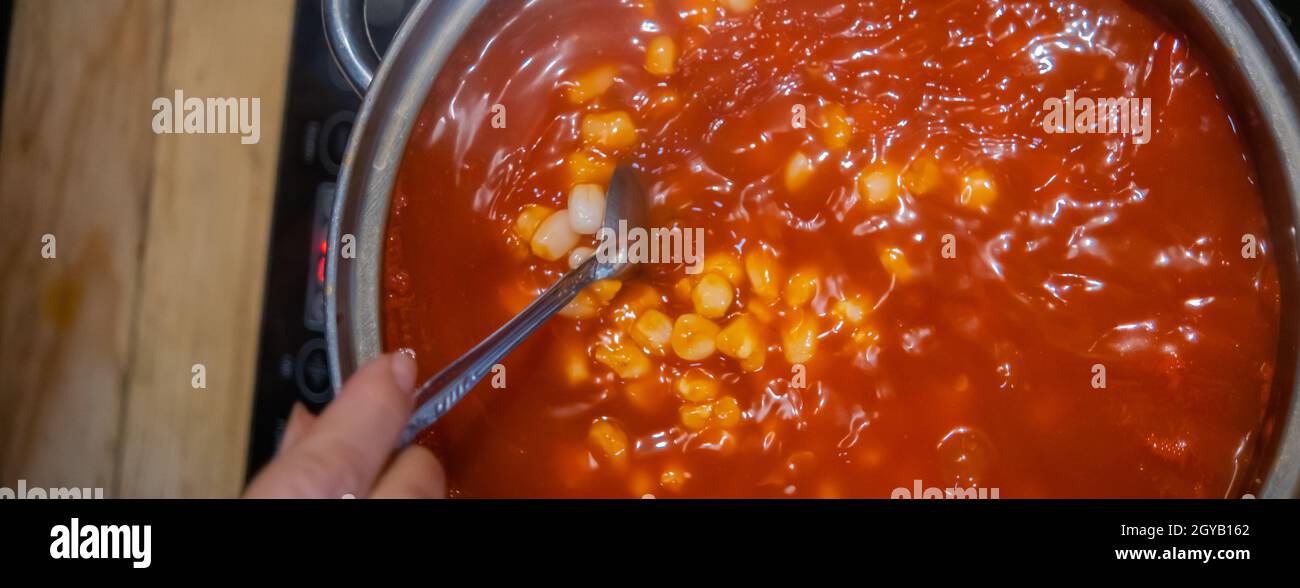 Delicious traditional Mexican pozole with corn kernels in cooking pot ...