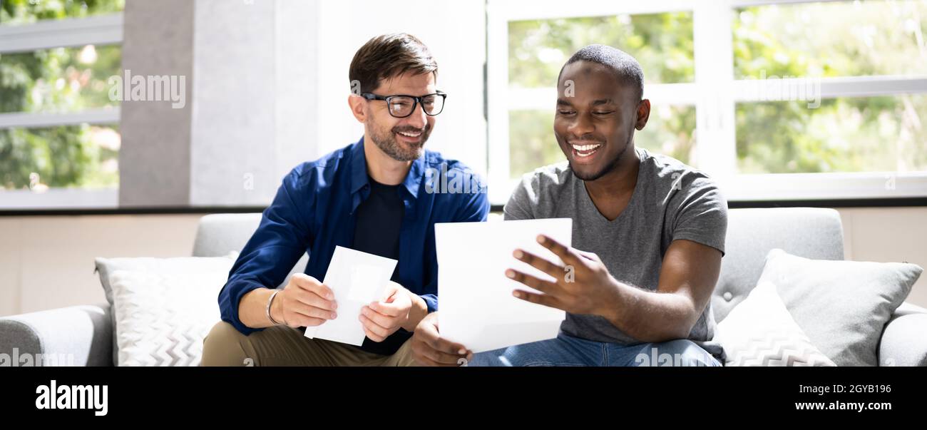 Happy Gay Couple Reading Letter Or Mail Stock Photo - Alamy