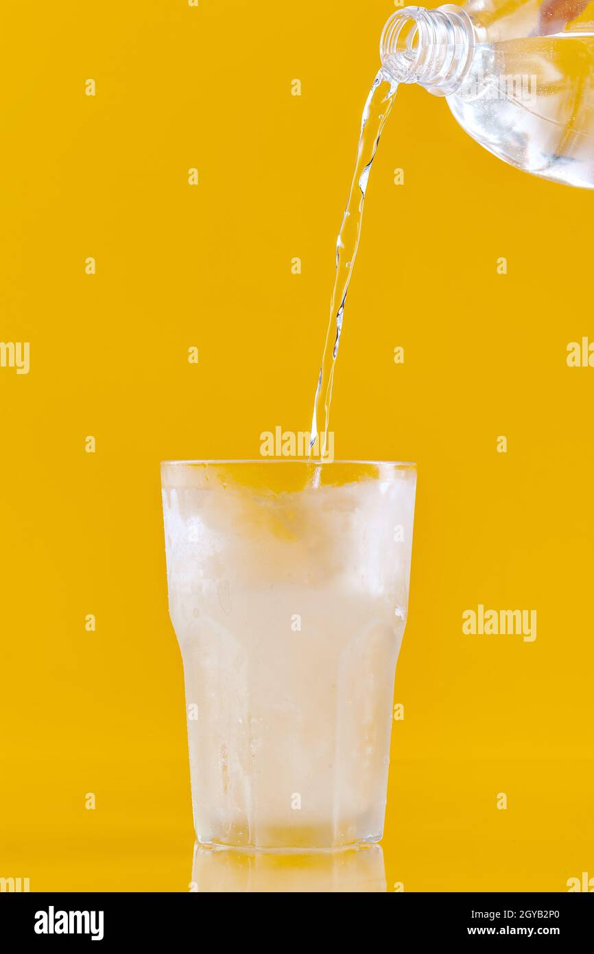 Cold water pouring from a bottle into a glass Stock Photo - Alamy