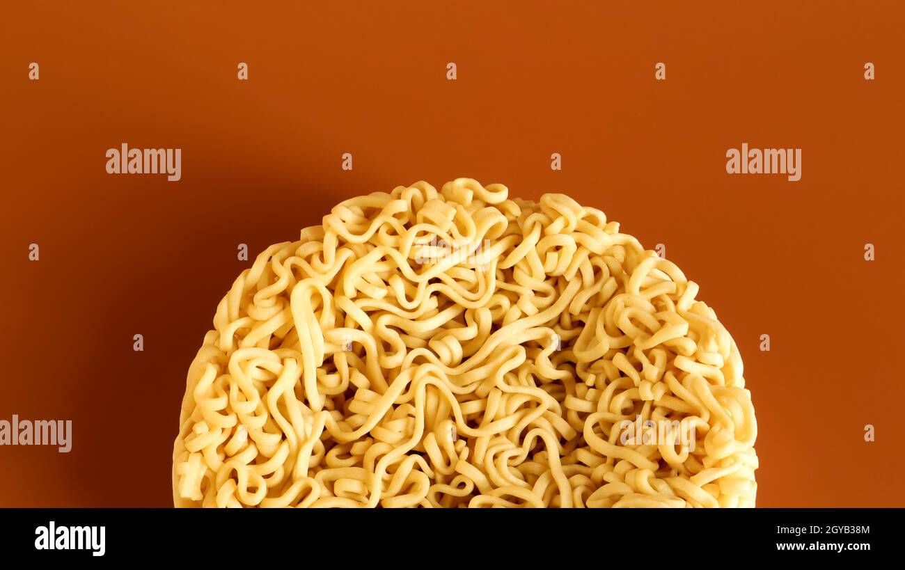 Korean instant noodles in the shape of a circle on a brown background ...