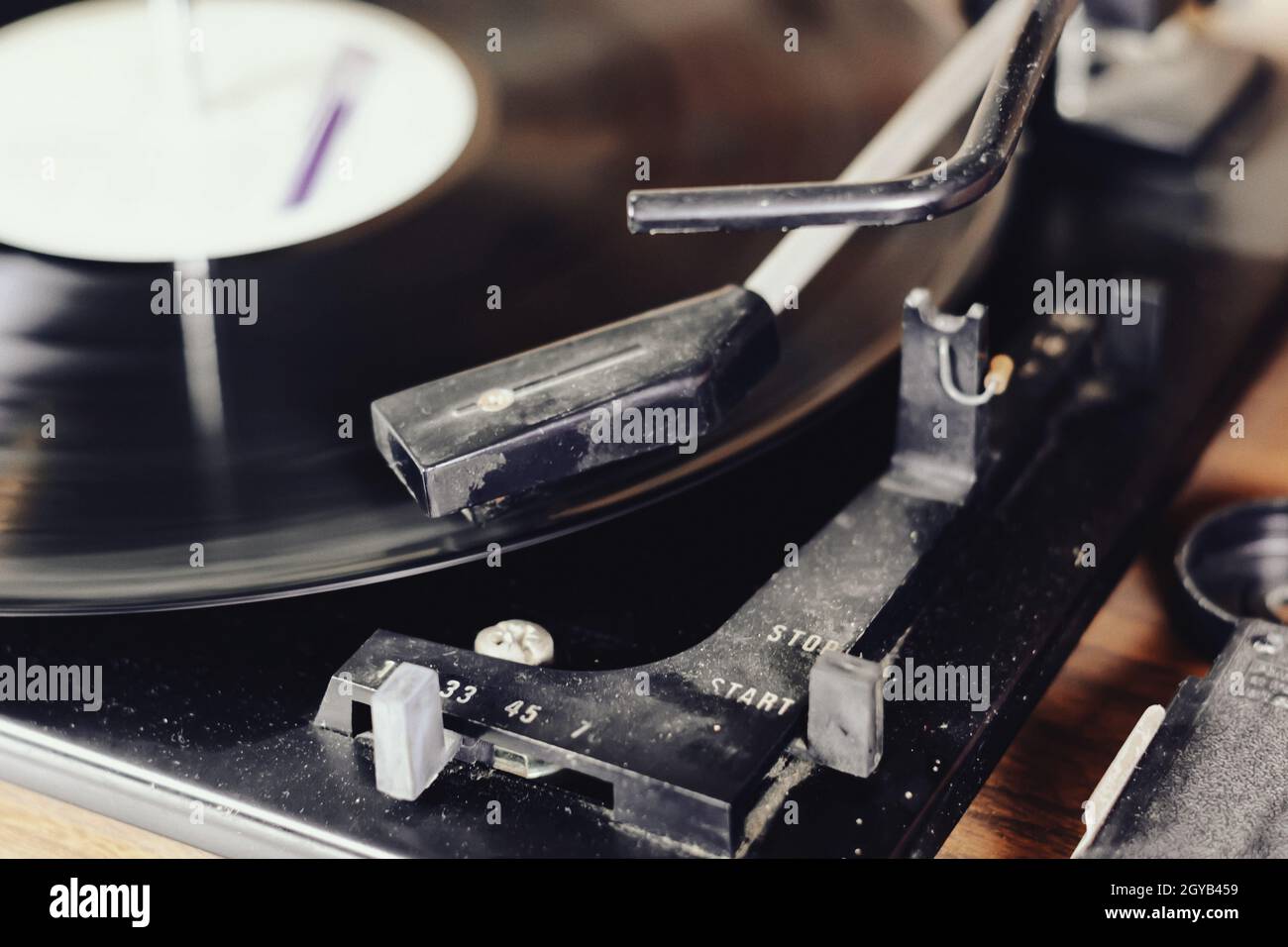 the needle of a turntable playing the tracks of a black vinyl record ...
