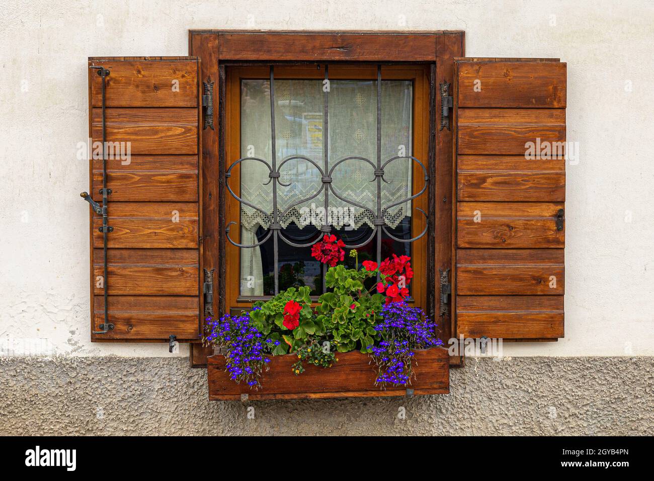 Typical alpine house windows with flowering plants Stock Photo - Alamy