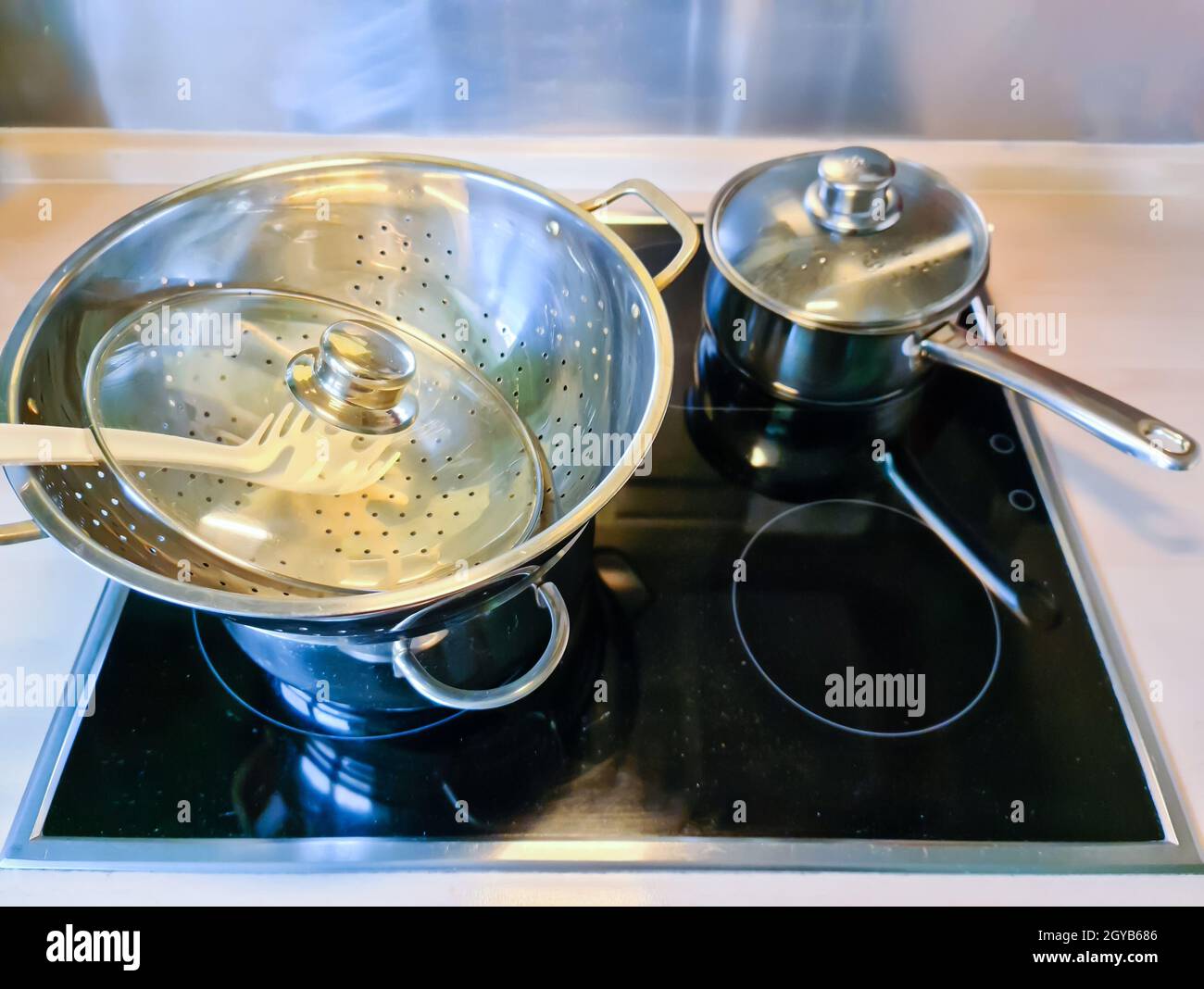 High angle view of a chrome pasta strainer in a pot on a stove Stock ...