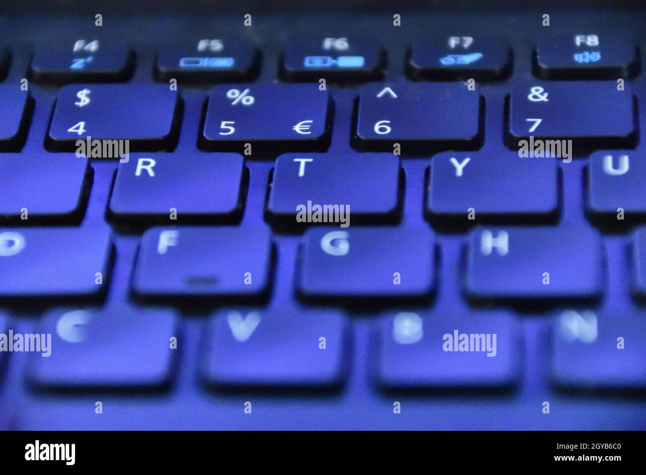 A laptop keyboard with blue light shining on it Stock Photo - Alamy