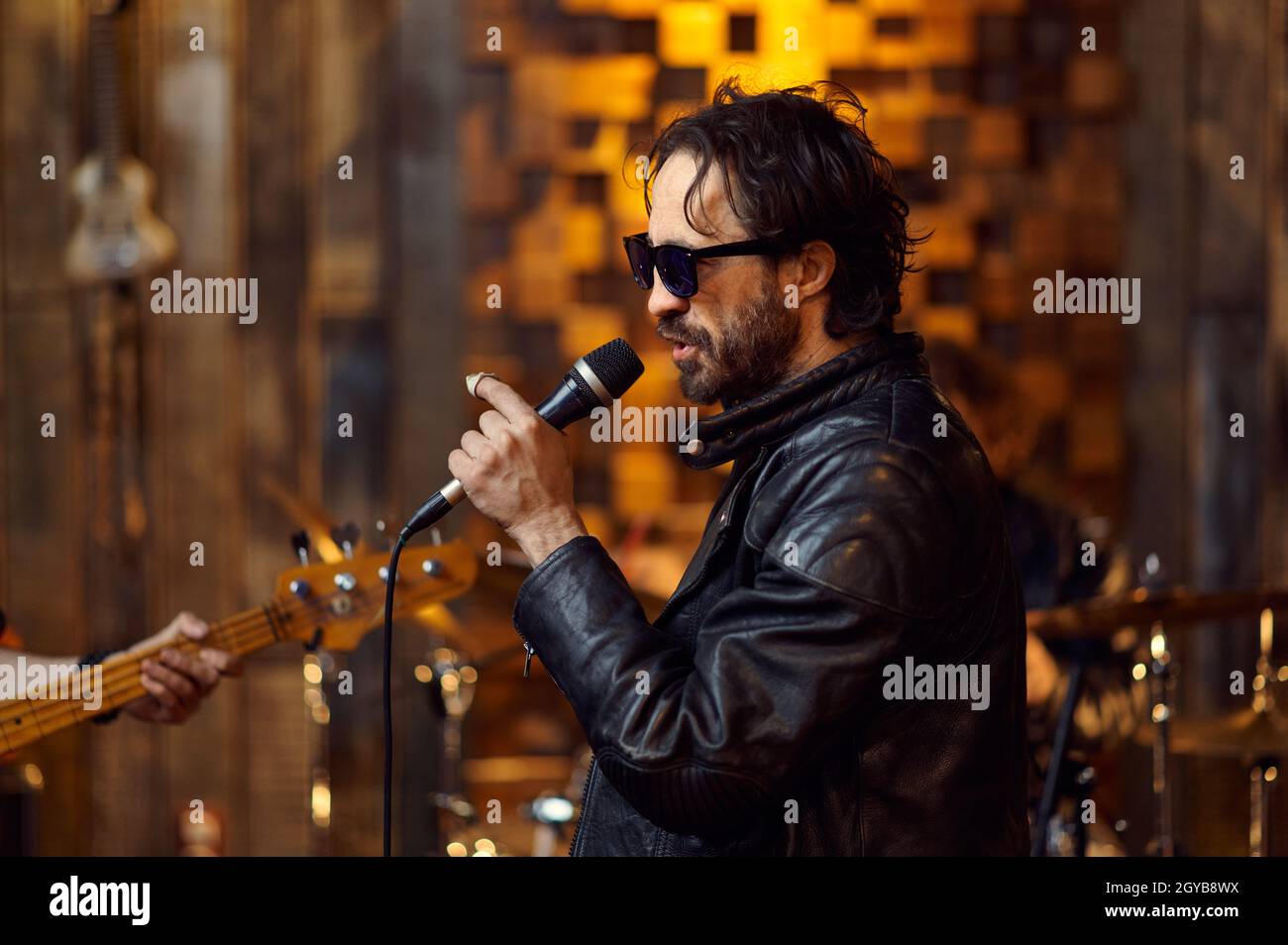 Male singer in sunglasses at microphone, song performing on stage. Rock ...