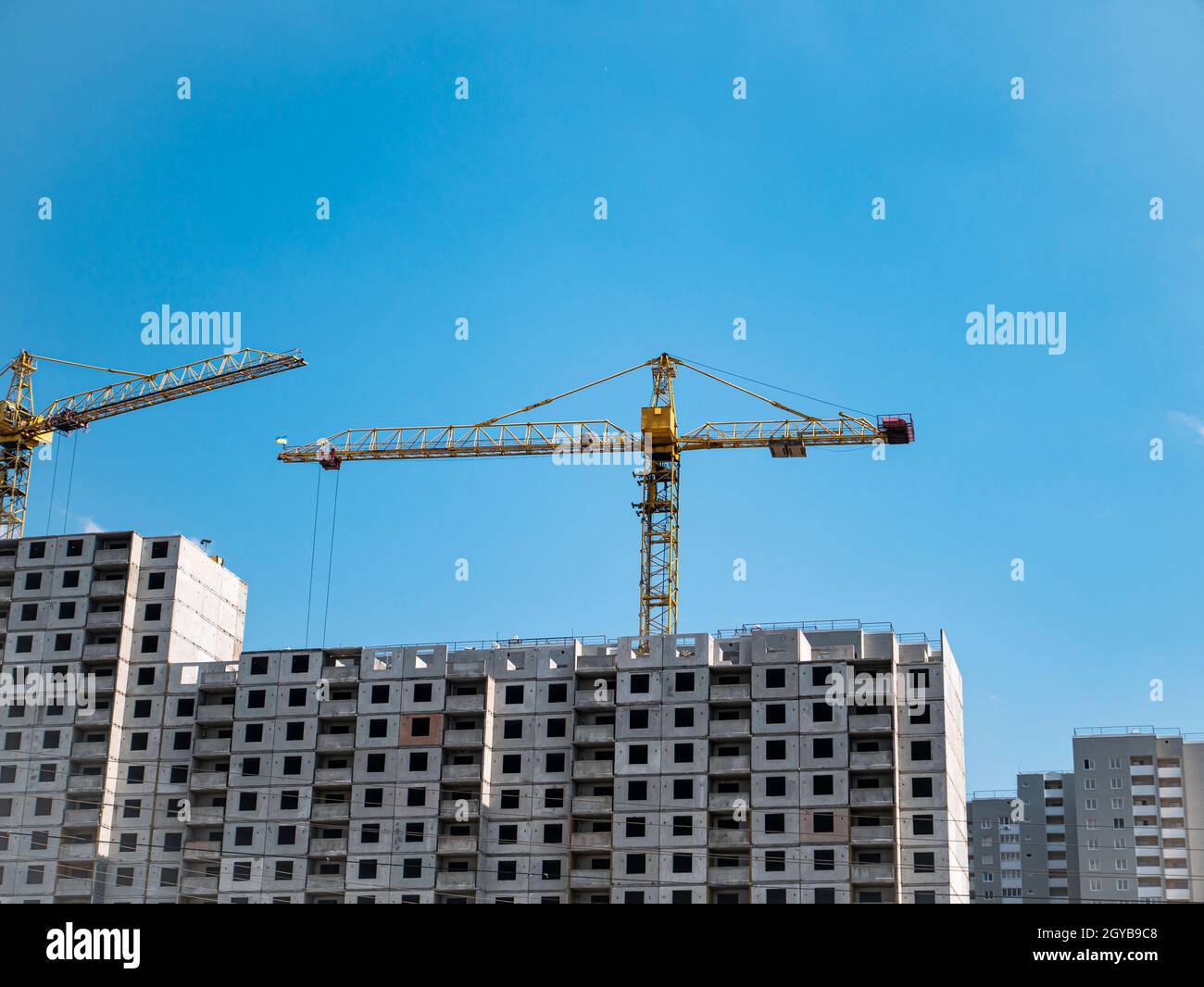 House construction with construction cranes on a background of blue sky ...