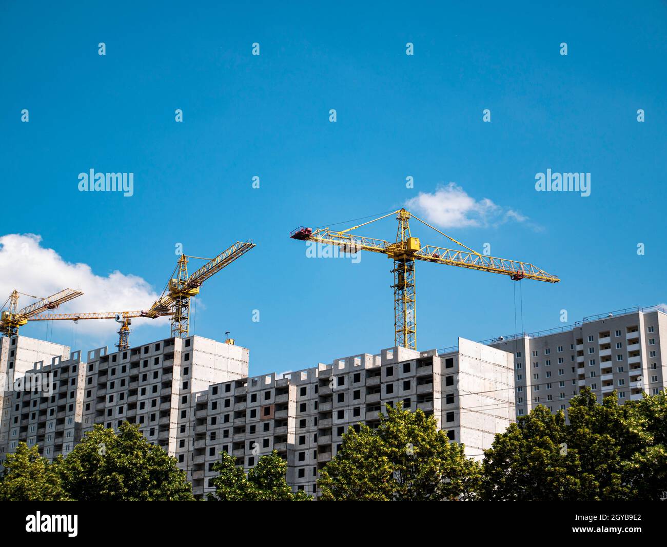 House construction with construction cranes on a background of blue sky ...